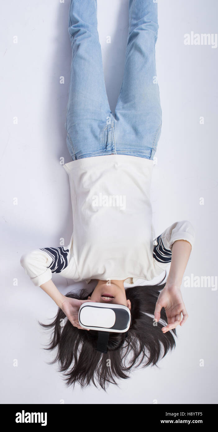 asian woman wearing VR headset, lying upside down, isolated white ...