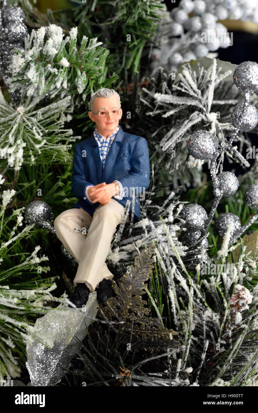 An elderly senior figurine man sitting on the branches of a christmas ...
