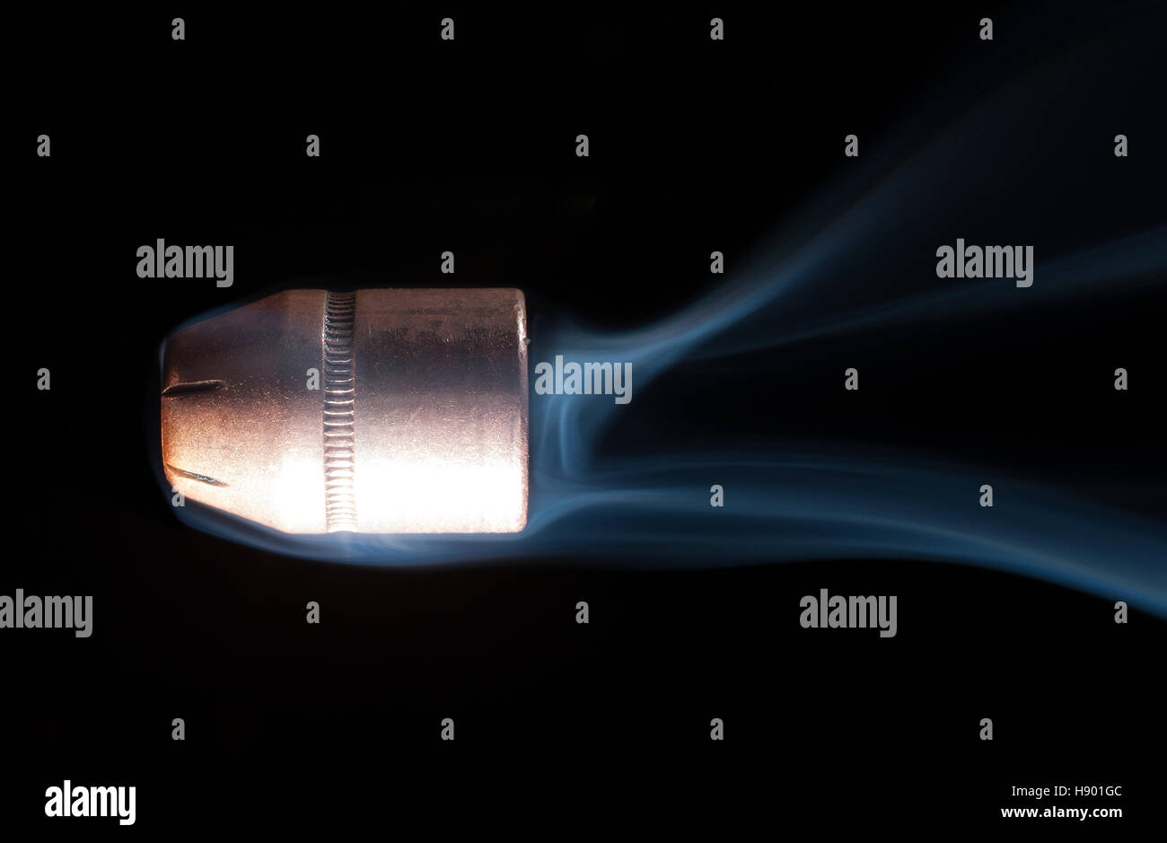 Hollow point handgun bullet with smoke trailing behind Stock Photo - Alamy