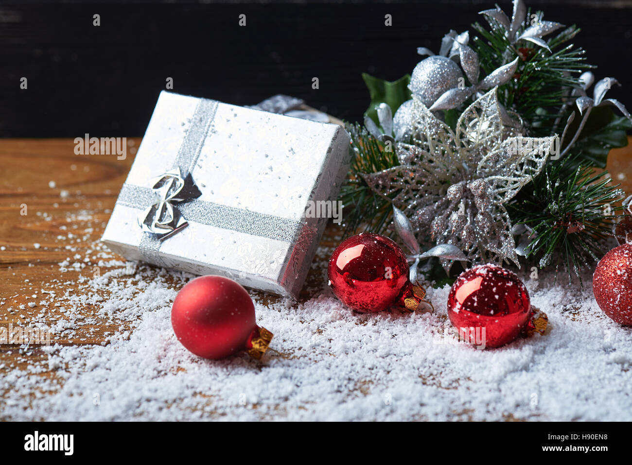Still life with red balls, presents and pine cones covered with snow ...