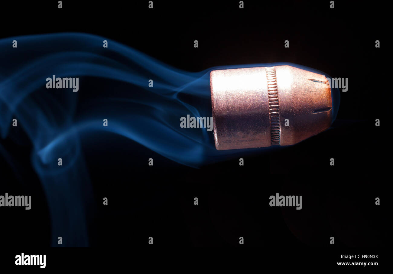 Flat nosed handgun bullet that is moving with smoke behind Stock Photo ...