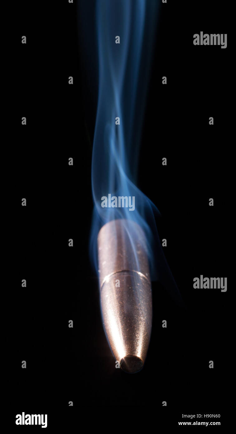 Copper jacketed bullet headed toward the camera with smoke Stock Photo ...