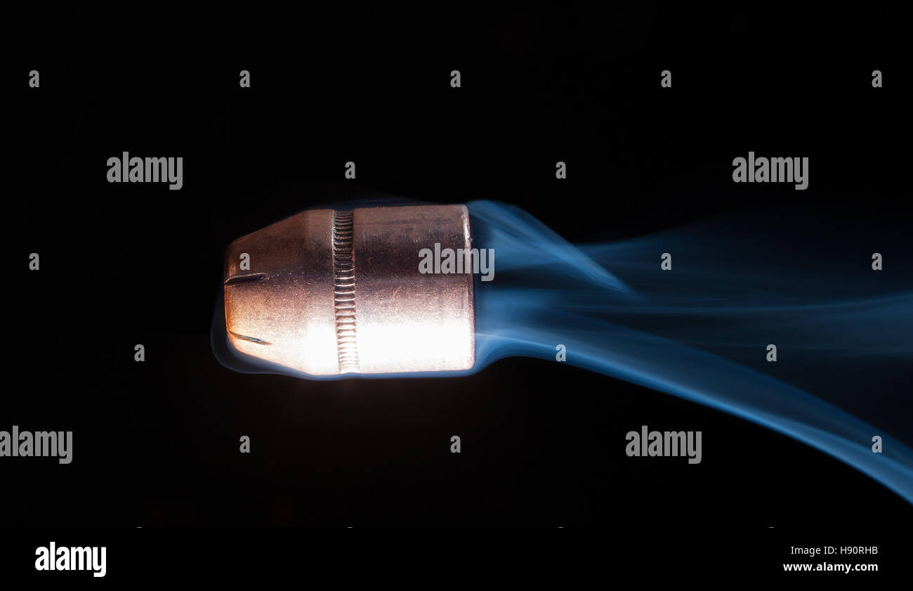 Hollow point handgun bullet with smoke trailing behind Stock Photo - Alamy