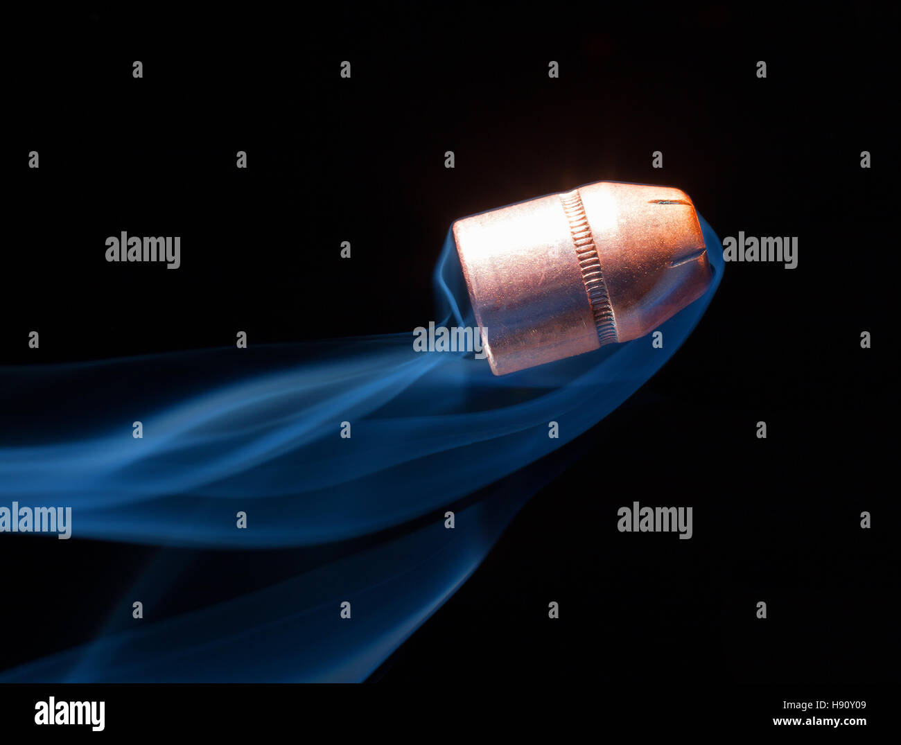 Copper handgun bullet heading slightly up with smoke behind Stock Photo ...