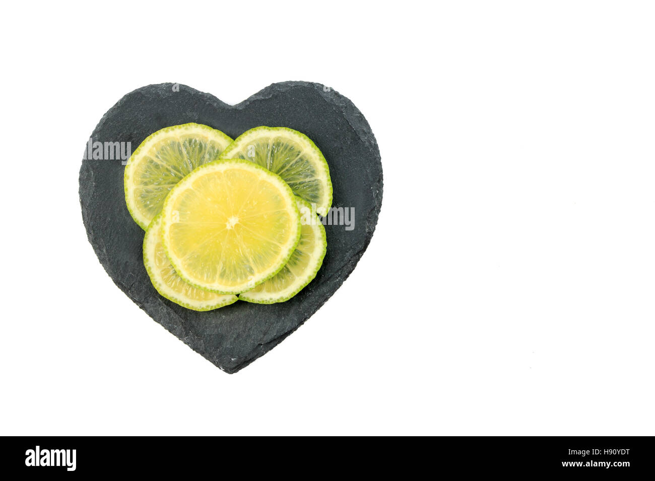 Lime slices on heart shaped black slate Stock Photo - Alamy