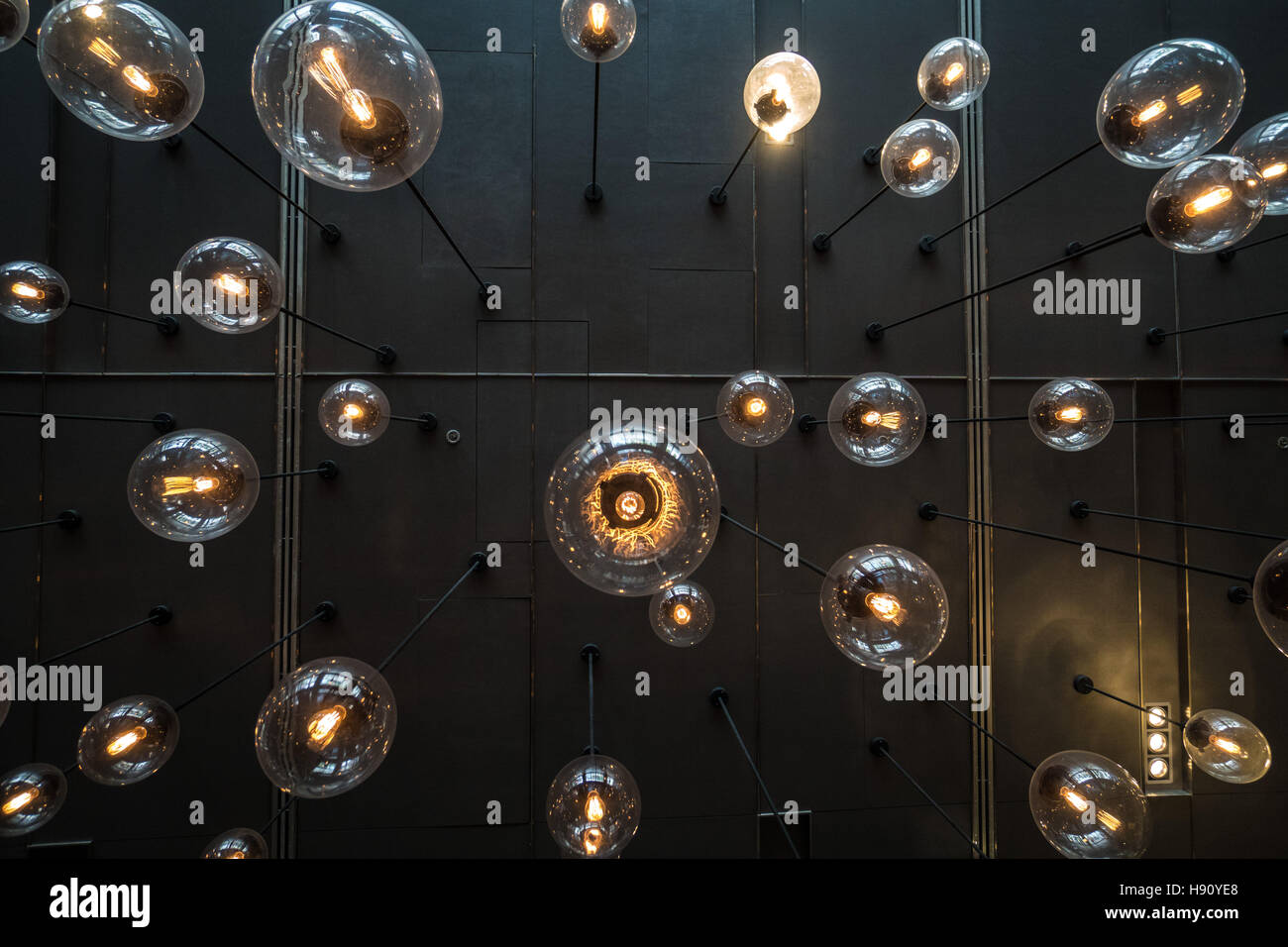 Bottom view of light bulbs background over dark wall Stock Photo - Alamy