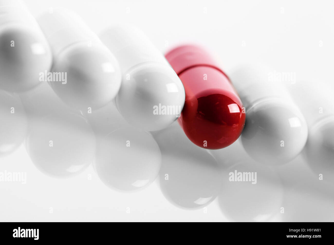 White capsules and one red in line. Studio shot Stock Photo - Alamy