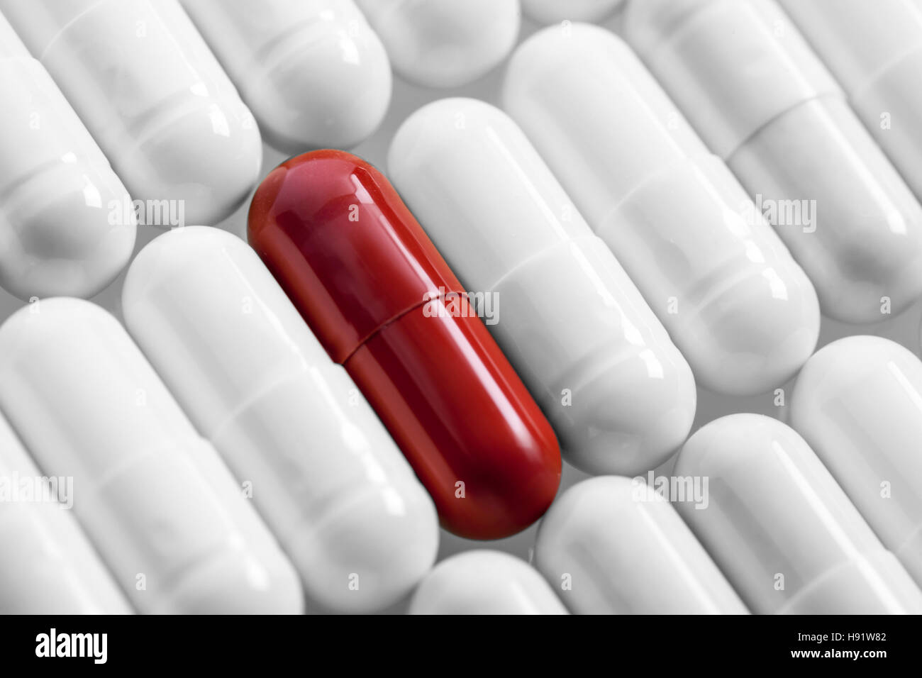 White capsules and one red in line. Studio shot Stock Photo - Alamy