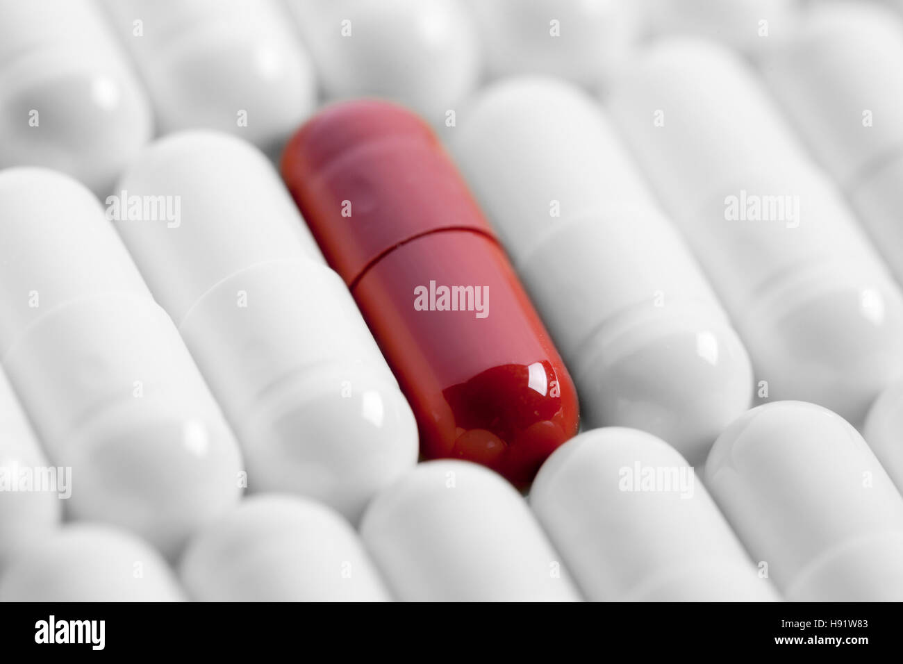 White capsules and one red in line. Studio shot Stock Photo - Alamy