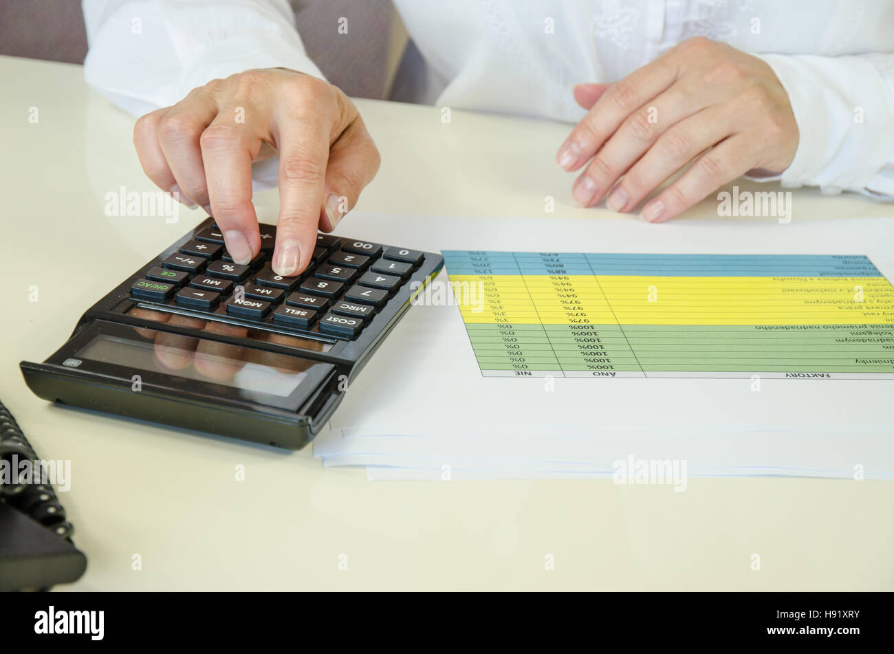 hand on calculator and colorful graph in the table in the office Stock ...