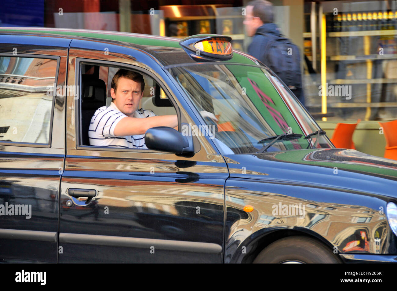 Man earning living with job driving at work in London as taxi driver in ...