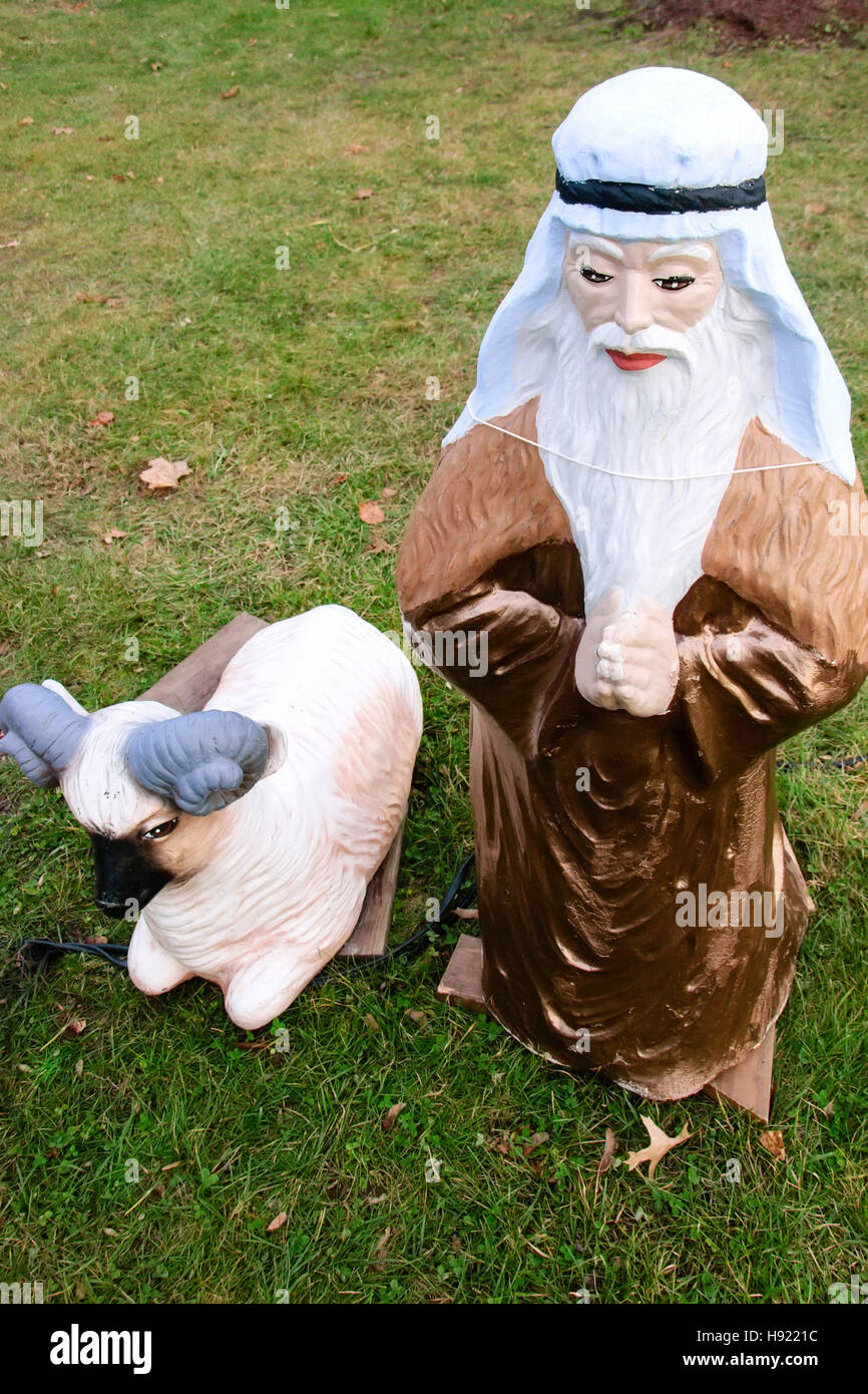 Closeup of figure of shepherd and sheep from outdoor Christmas nativity ...