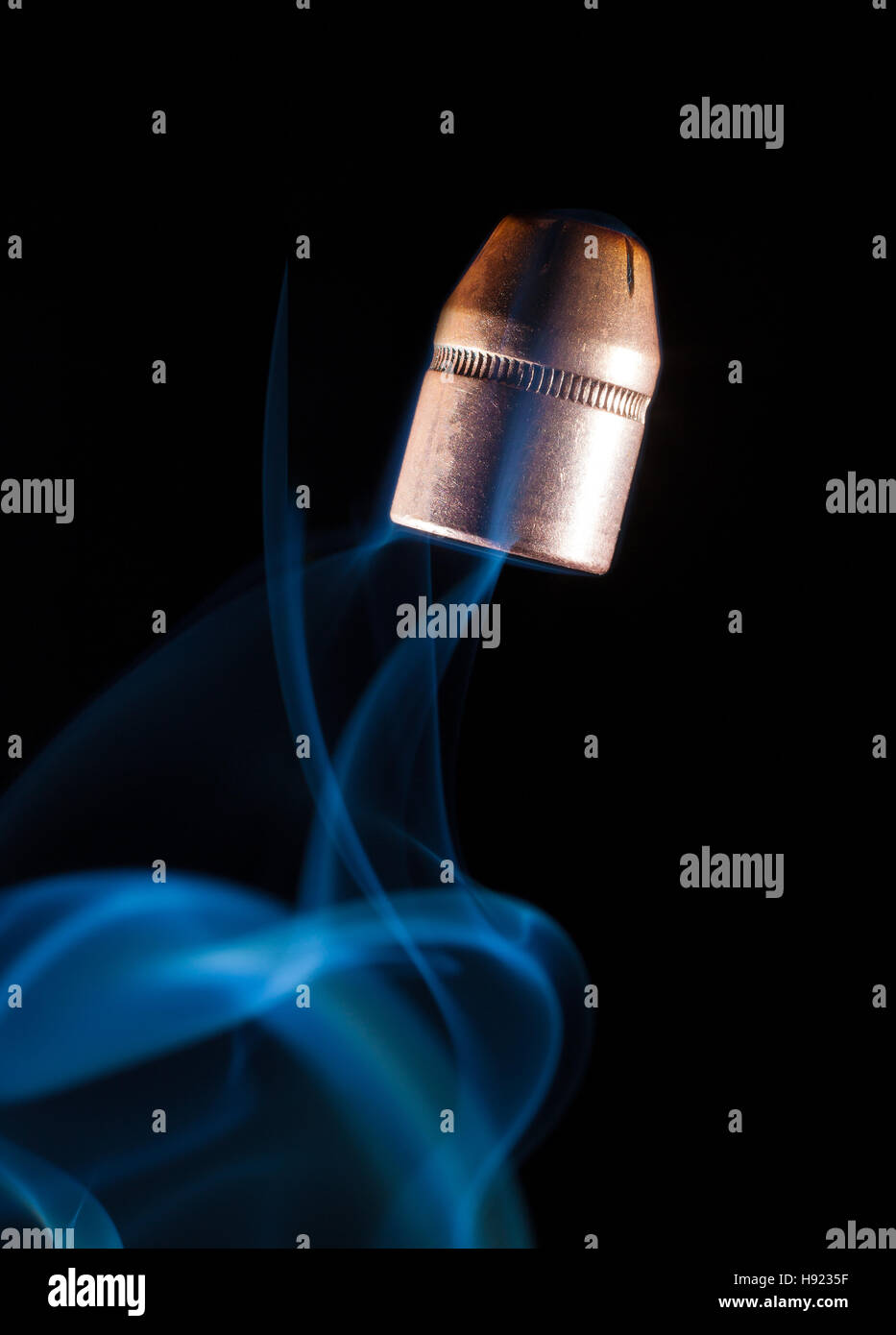 Pistol bullet that is going up with smoke behind Stock Photo - Alamy