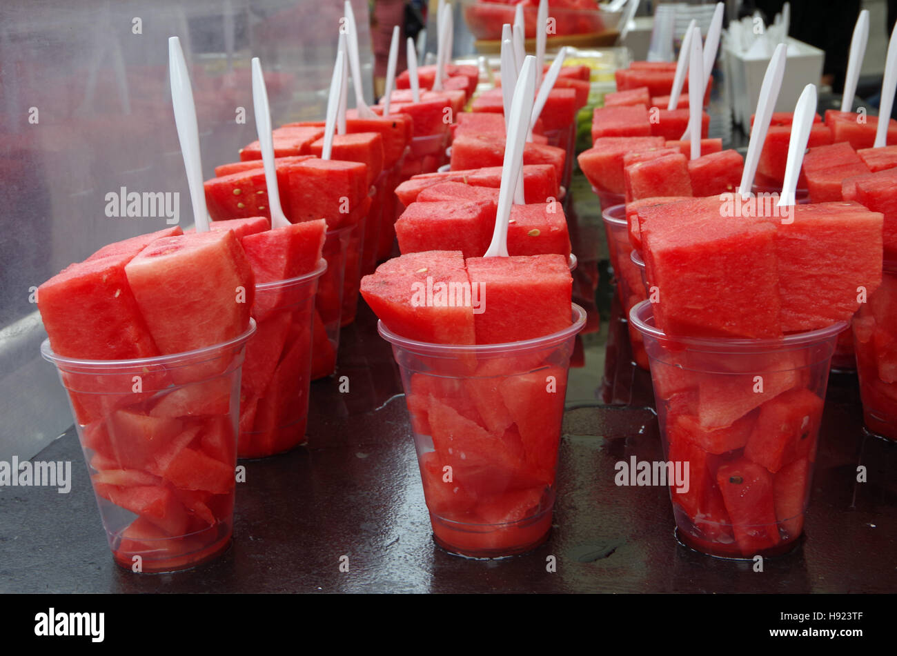 Translucent plastic cups filled with watermelon chunks and white ...