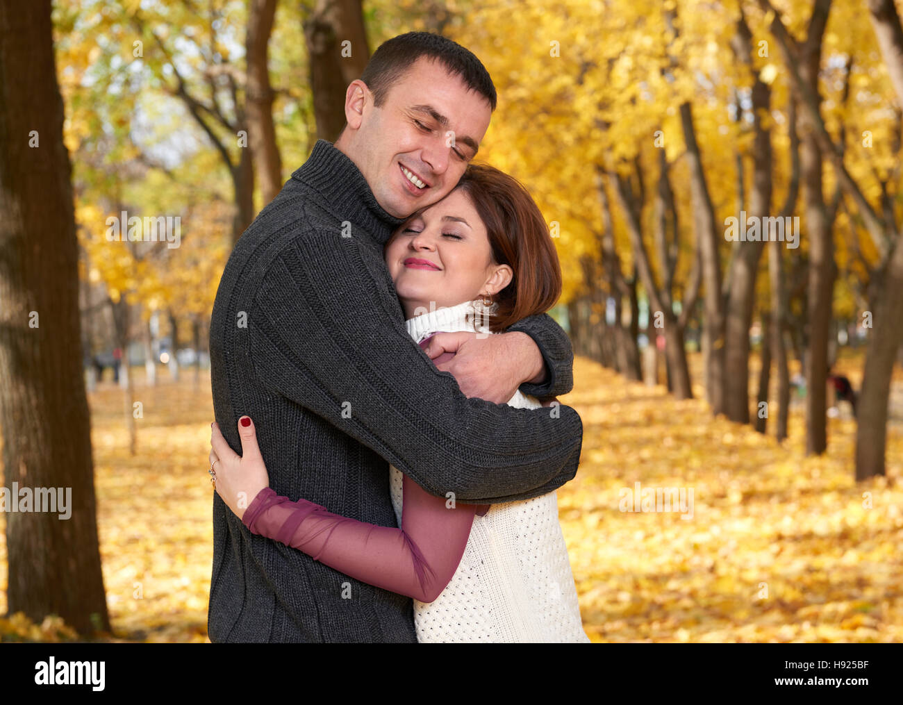 romantic people, happy adult couple embrace in autumn city park, trees ...
