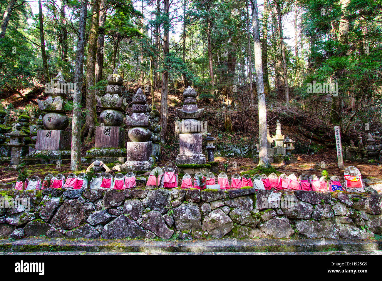 Japan, Koyasan, Okunoin ancient cemetery. Long Row of red-bibbed jizo ...