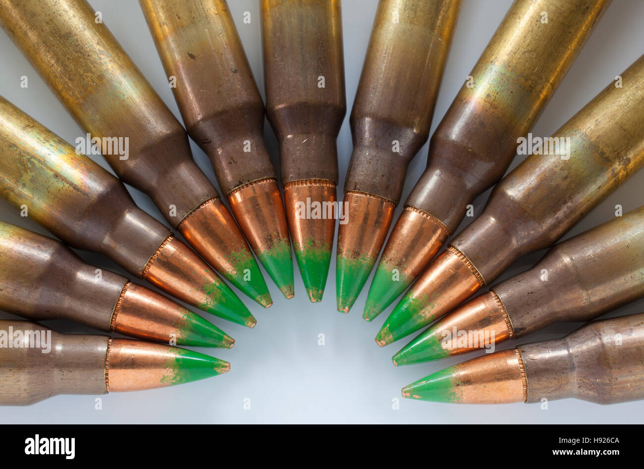 Cartridges on white loaded with bullets with green tips in a semi ...