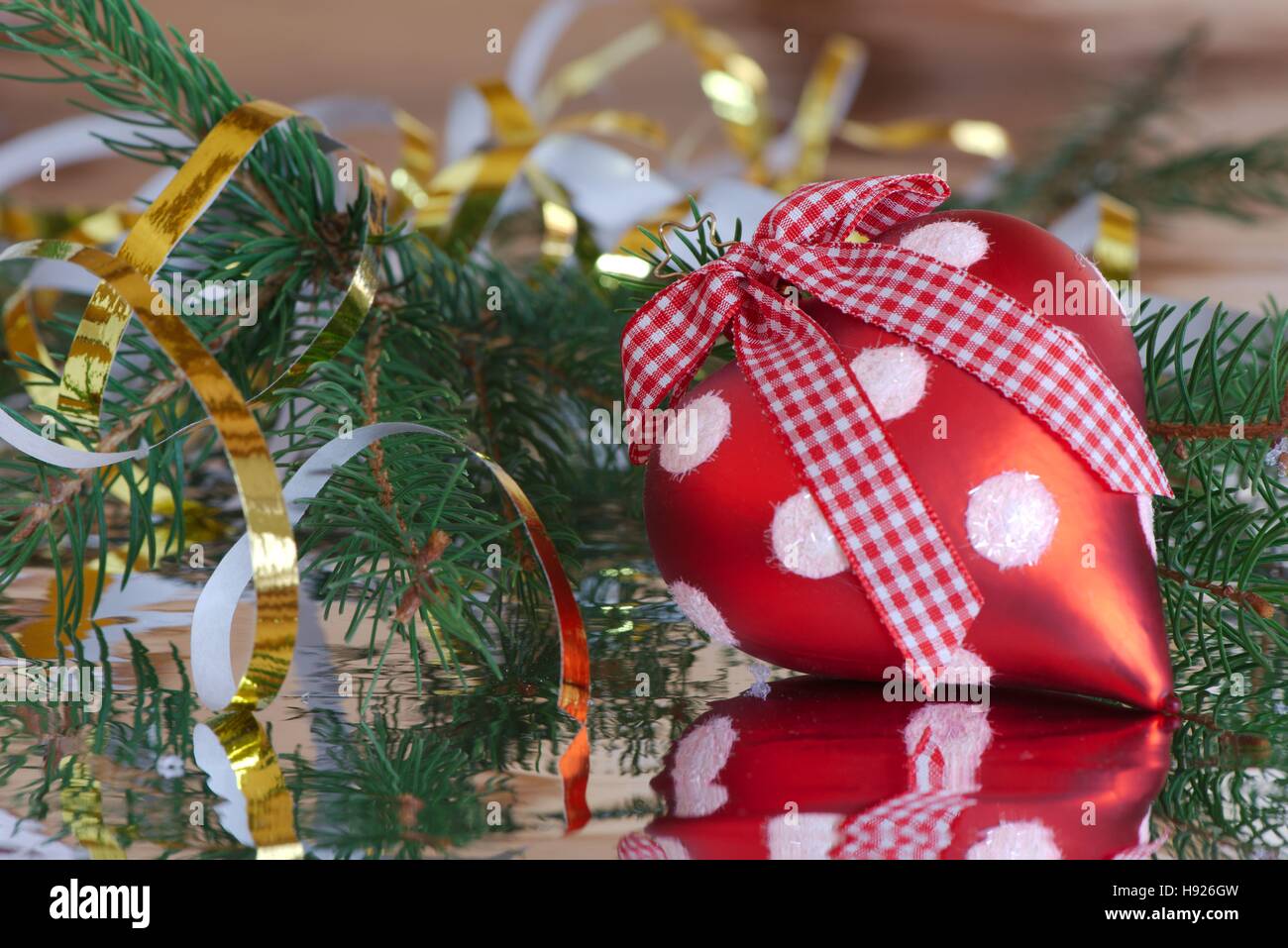 Red Christmas heart with golden serpentine and a Christmas tree branch ...