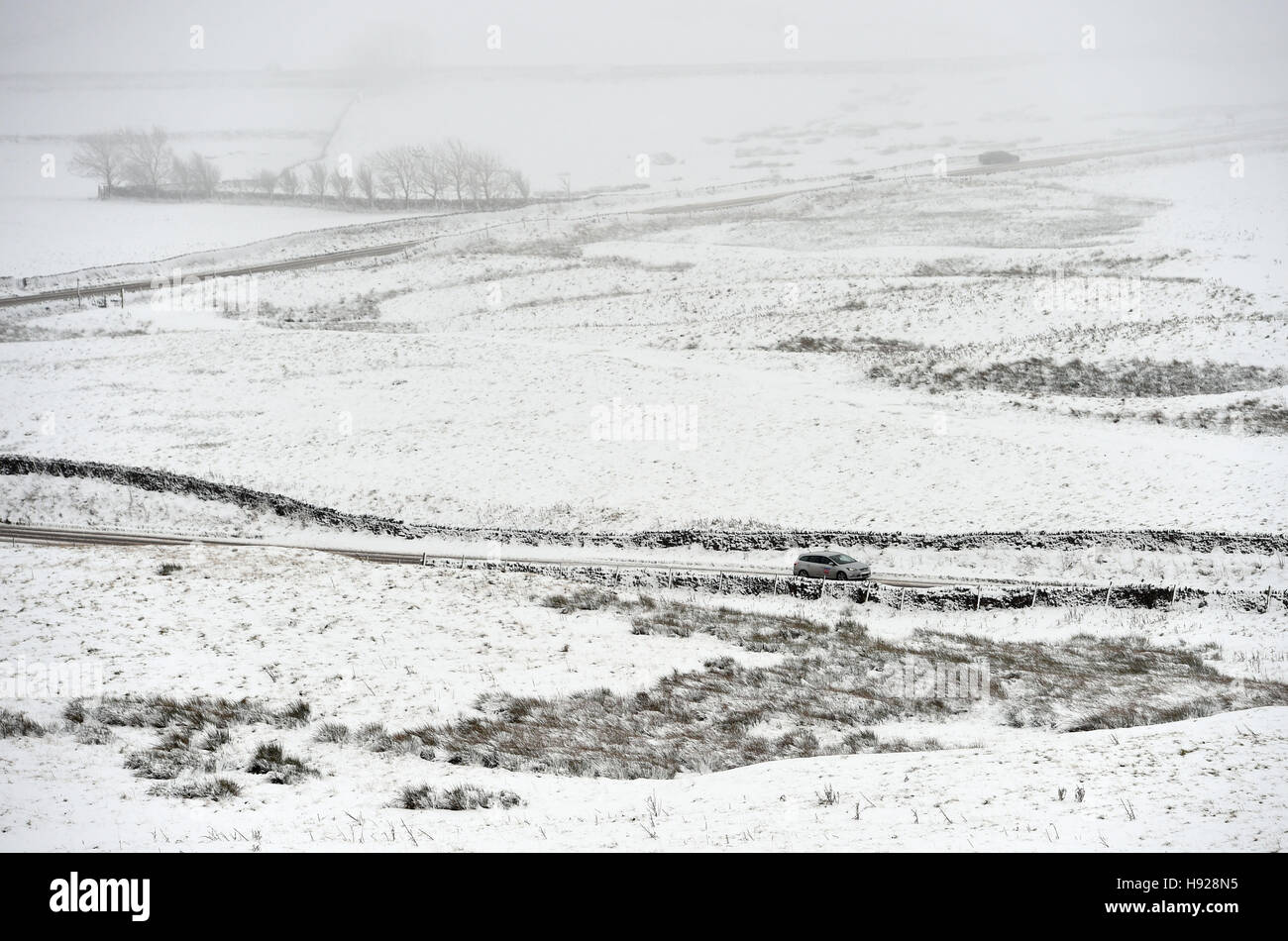 A car makes its way through the snow from Mam Tor, Derbyshire, after ...