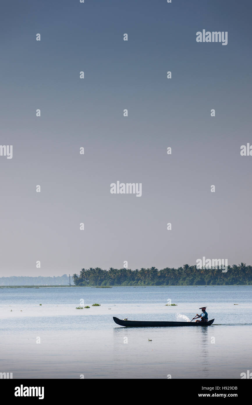 A fisherman scaring the fish towards his net by splashing in the water ...