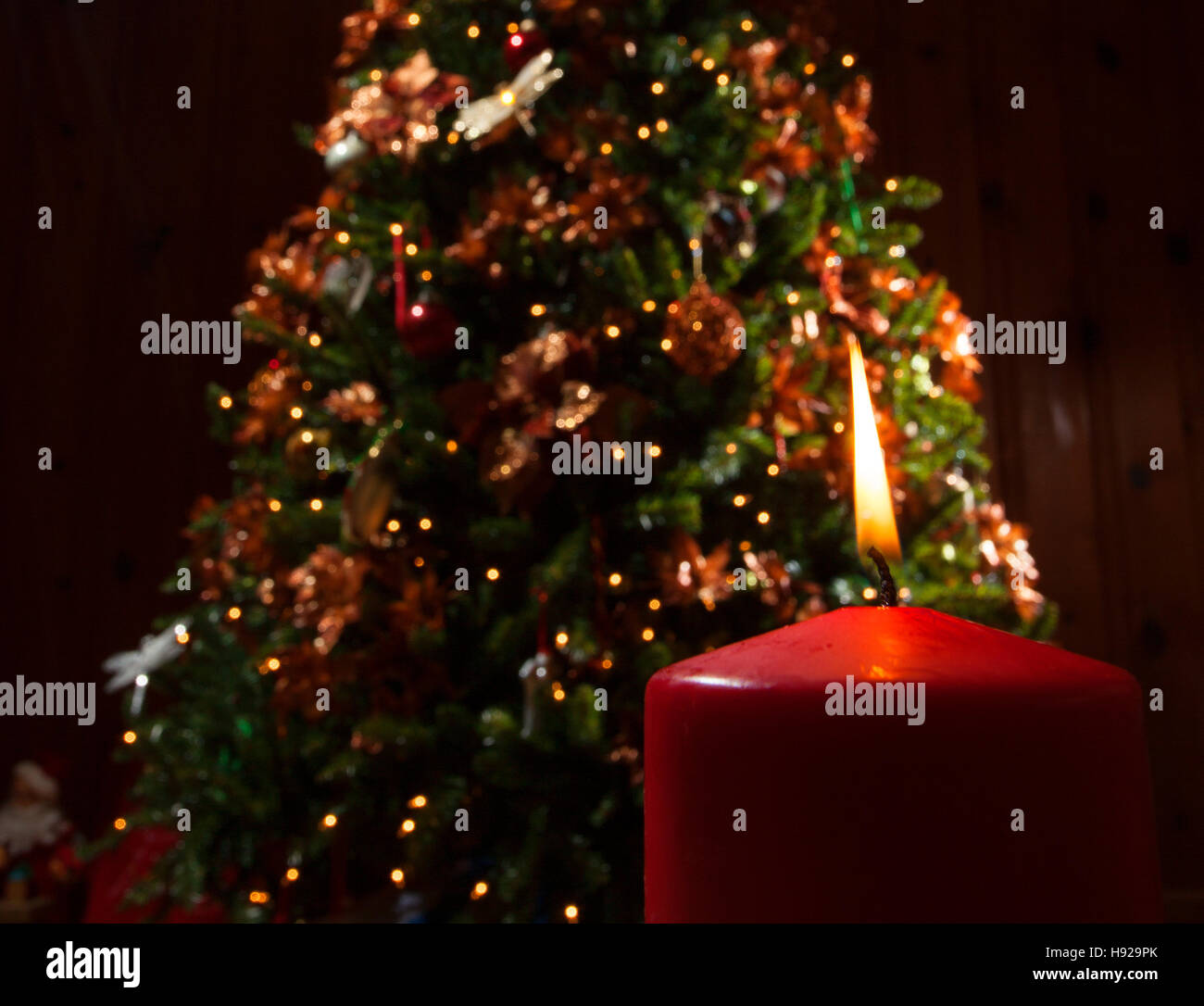 Red candle and flame in front of a decorated Christmas tree Stock Photo ...