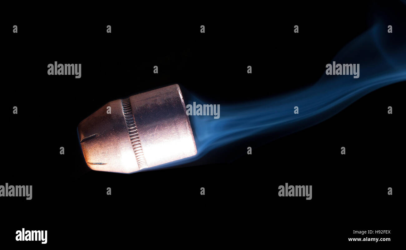 Copper handgun bullet with smoke behind that looks like it is going ...
