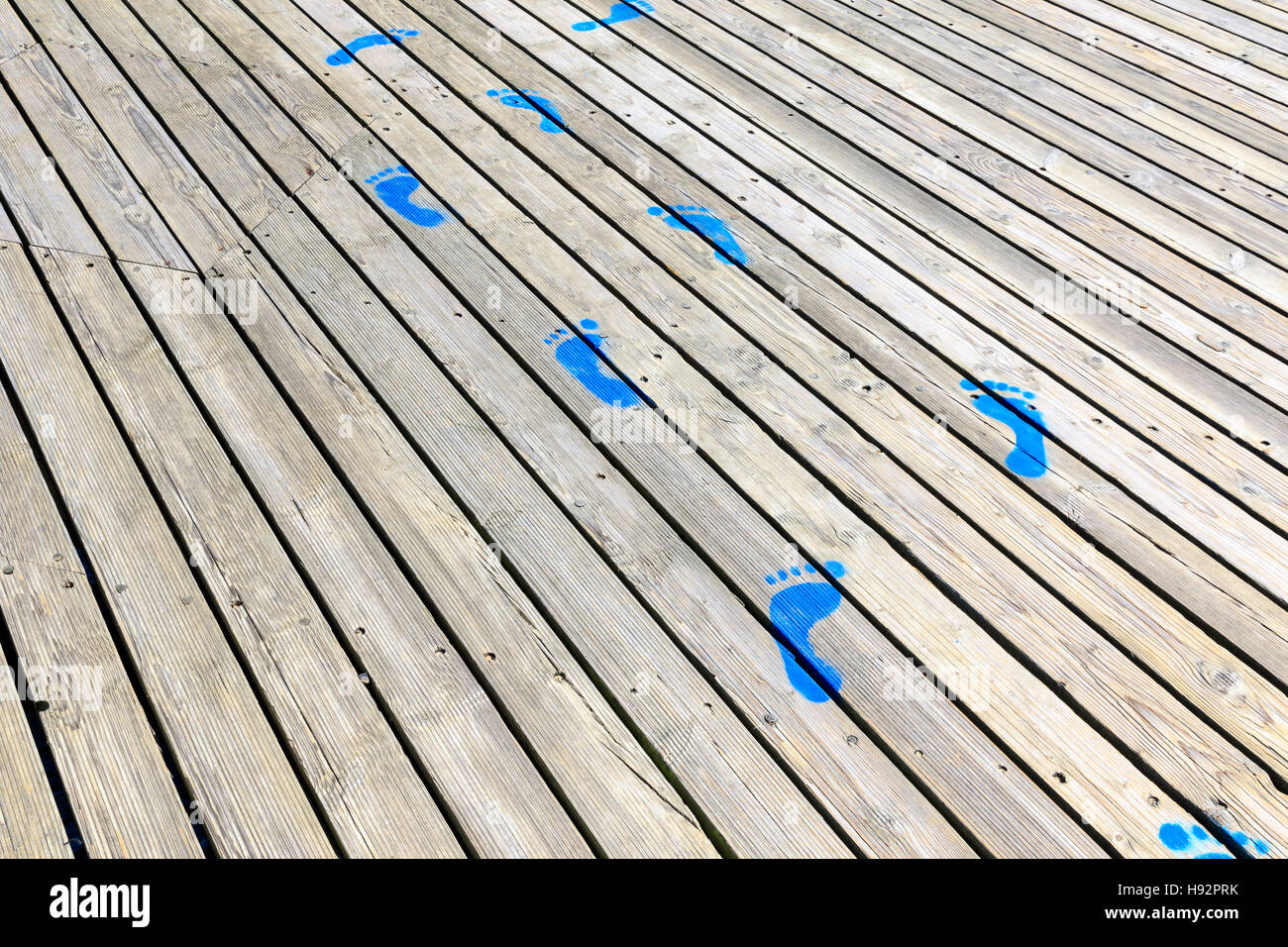 Blue painted footprints on wooden background Stock Photo - Alamy