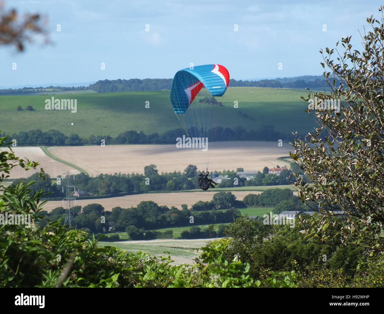 paraglider flying over fields Stock Photo - Alamy