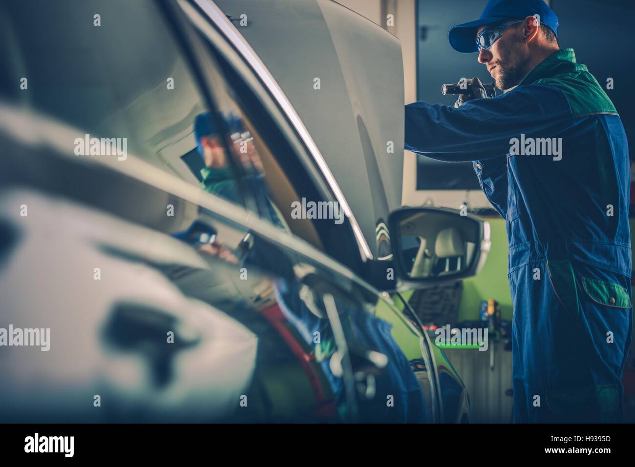 Car Mechanic Examining Vehicle Under the Hood. Caucasian Car Mechanic ...