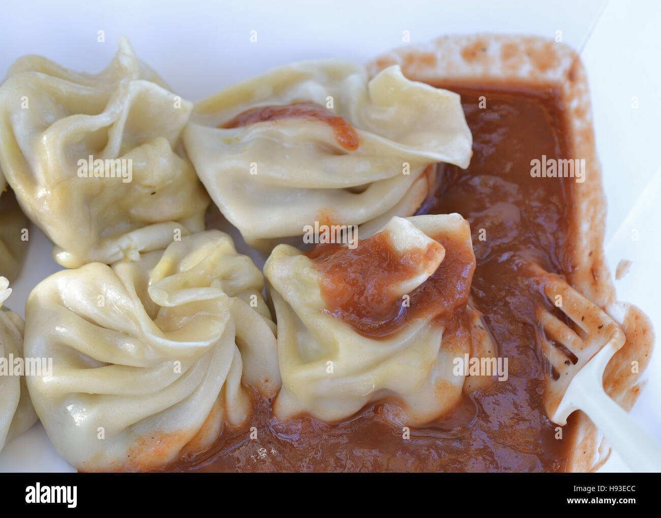 Closeup on momo, steamed cooked momos with tomato sauce.- served in a ...