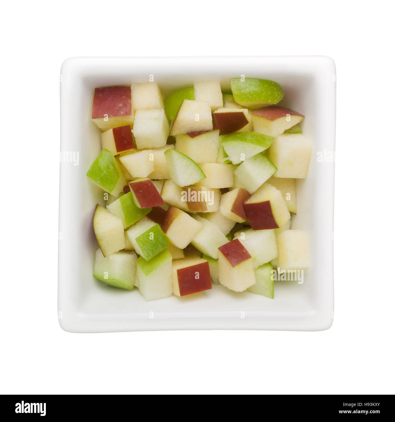 Diced green and red apple in a square bowl isolated on white background ...