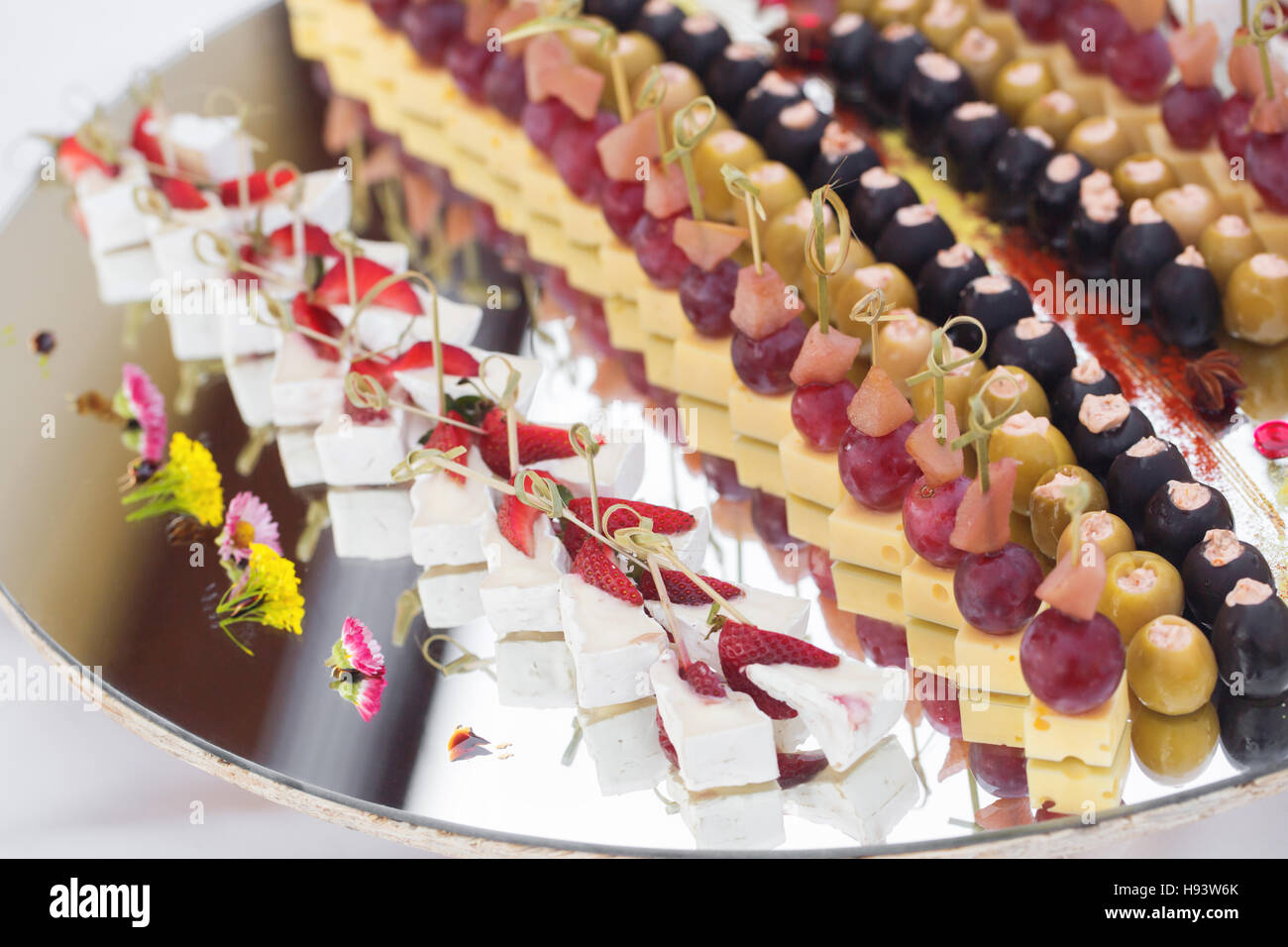 Catering banquet table with baked food snacks, sandwiches, cakes, cups ...
