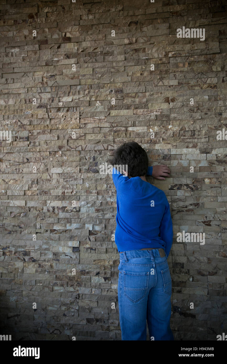 10 years old boy hiding face against the wall Stock Photo - Alamy