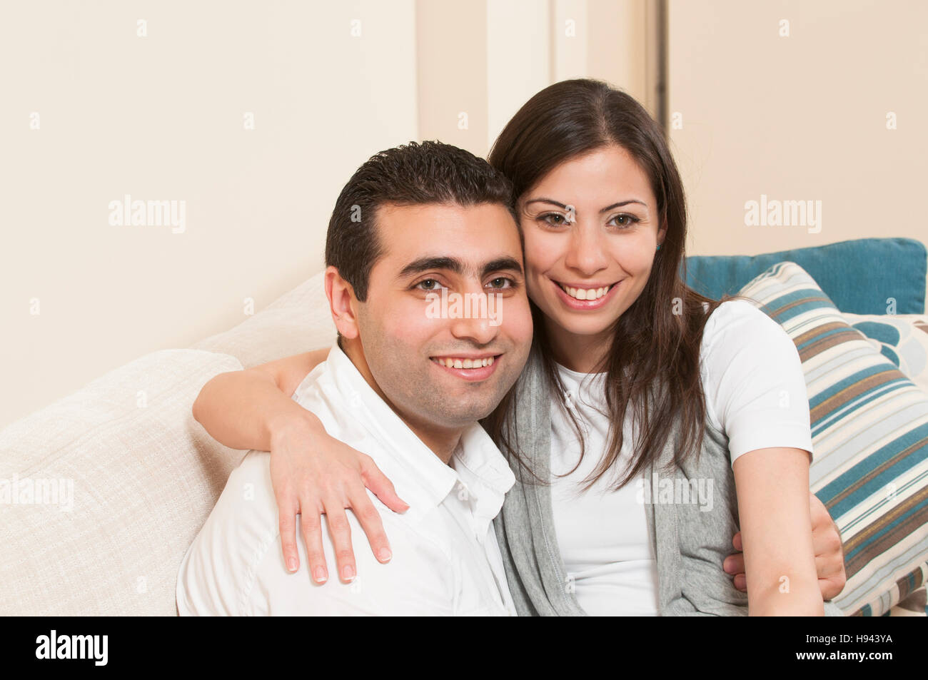 Happy couple sitting together on the sofa Stock Photo - Alamy