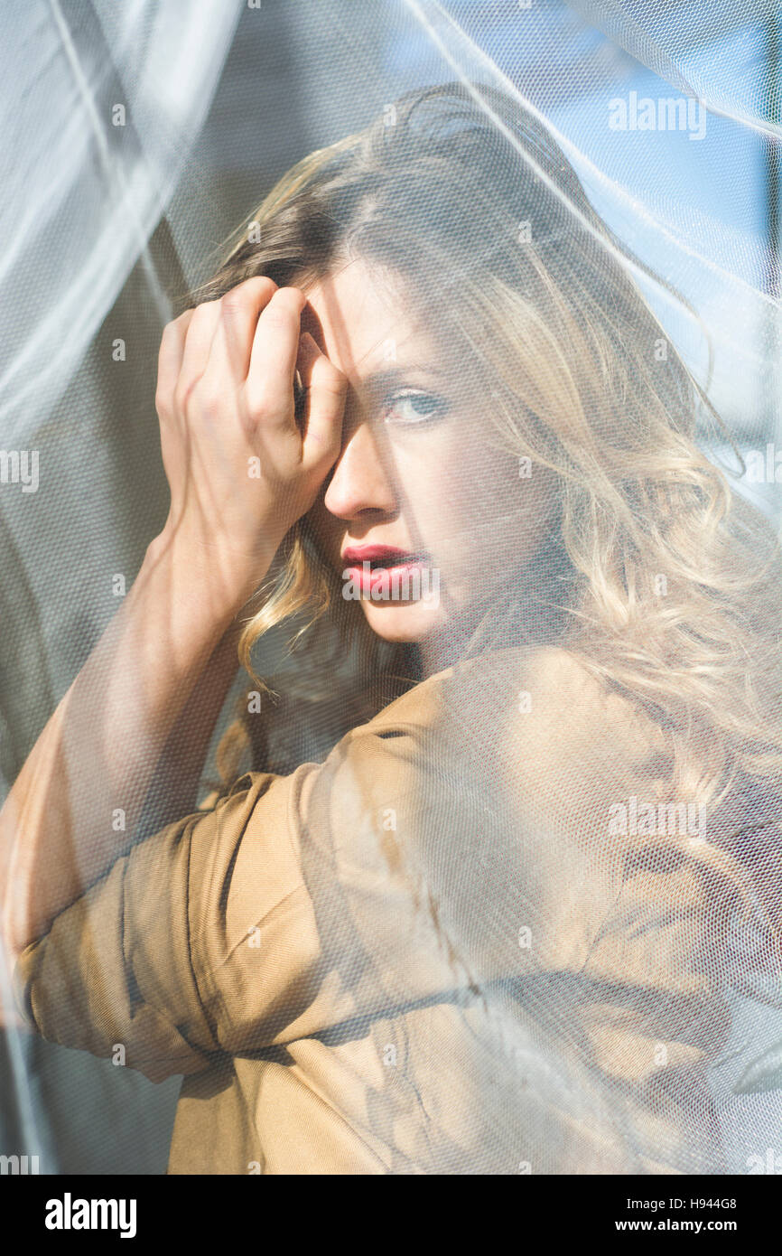 Scared young woman hiding face with hand Stock Photo - Alamy