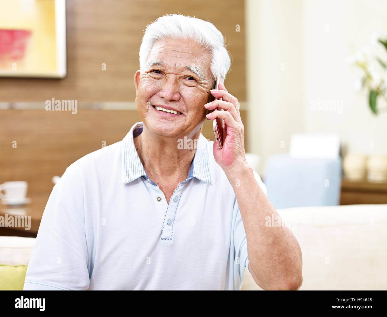 senior asian man calling using cellphone, looking at camera smiling ...