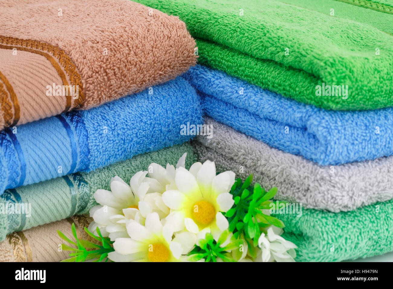 Colorful towels stack and flowers closeup picture Stock Photo - Alamy