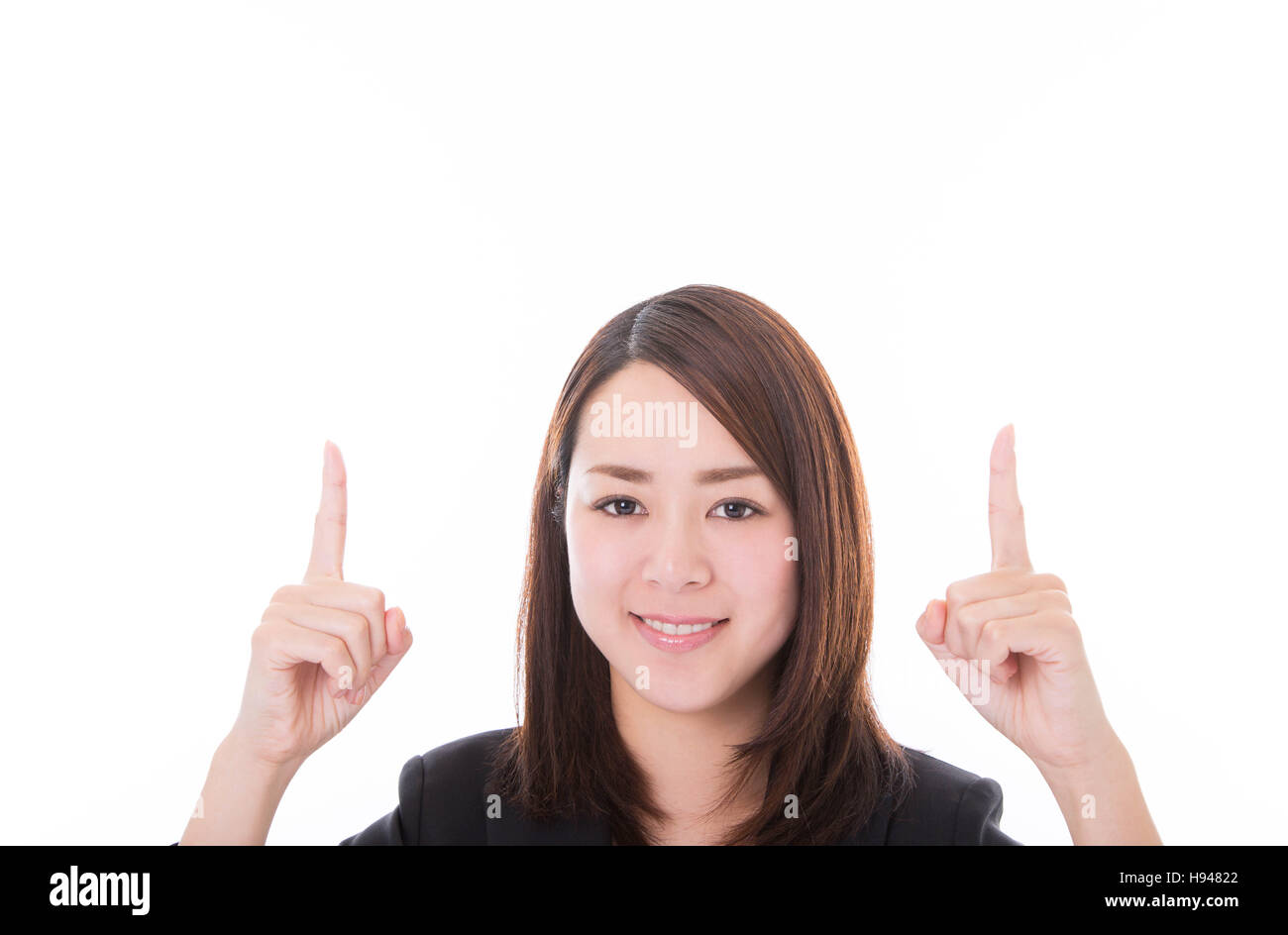 Portrait of young business woman pointing up at white background Stock ...