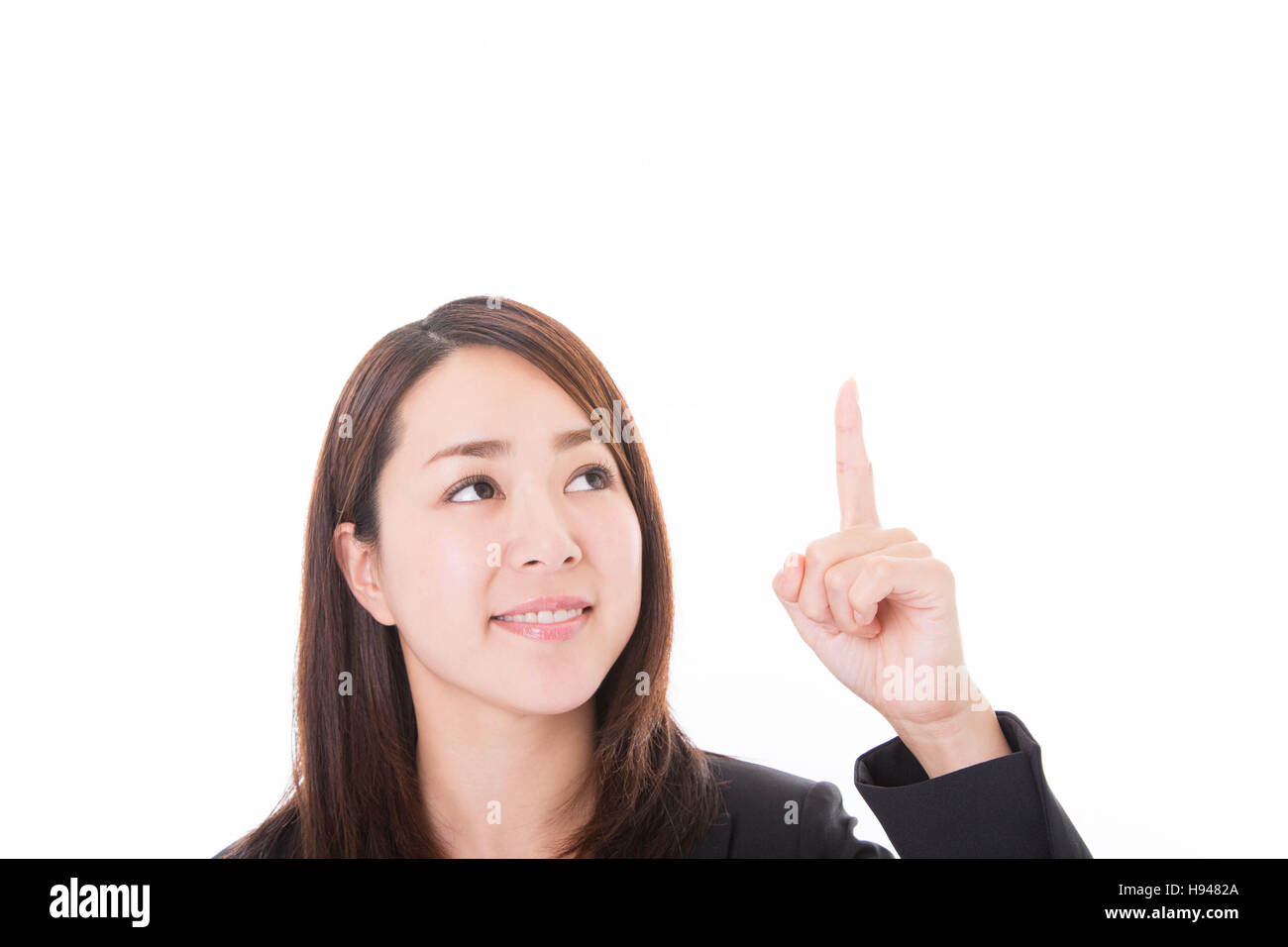Portrait of young business woman pointing up at white background Stock ...
