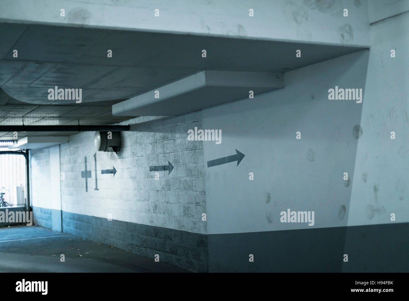 Arrow signs on concrete wall in parking garage Stock Photo - Alamy