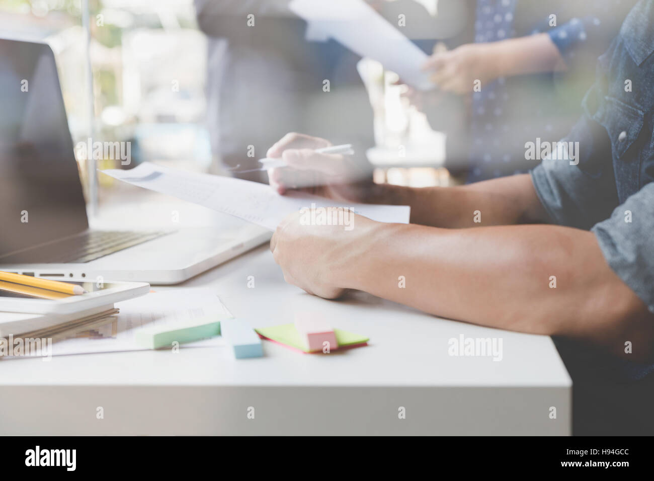 people working with document and laptop computer meeting in office ...