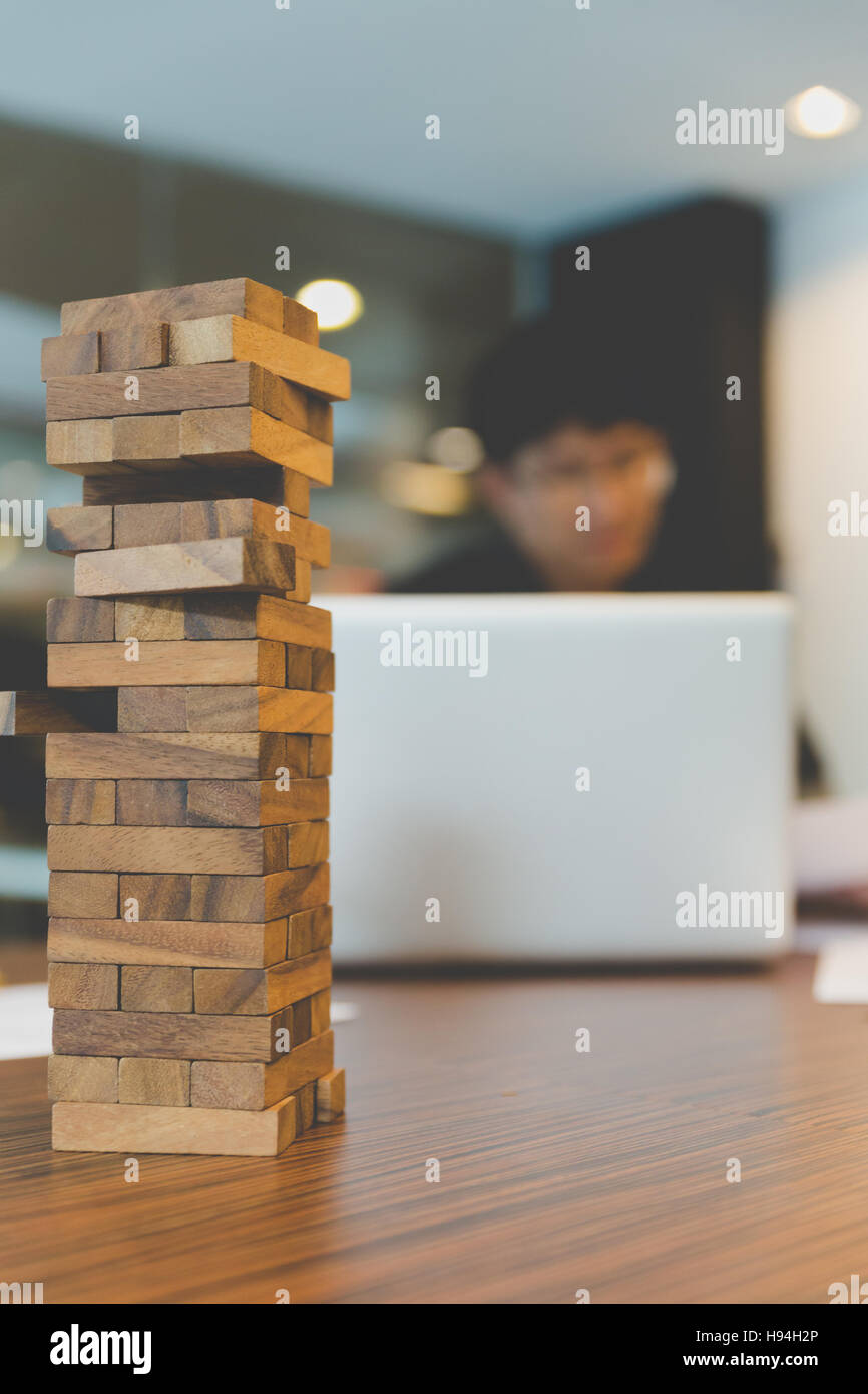 wood blocks stack game with background of businessman working in office ...