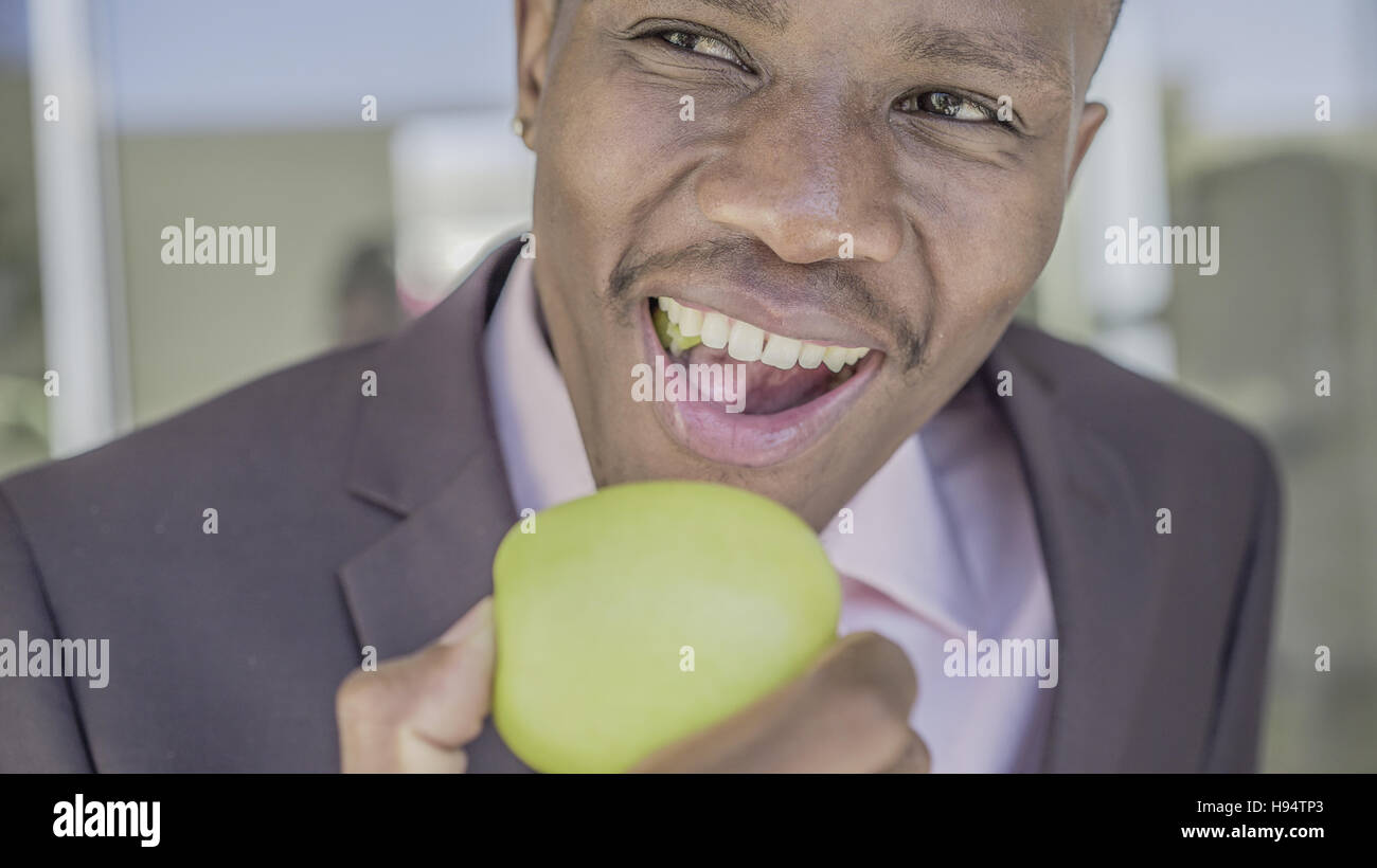 African man eating an apple Stock Photo - Alamy