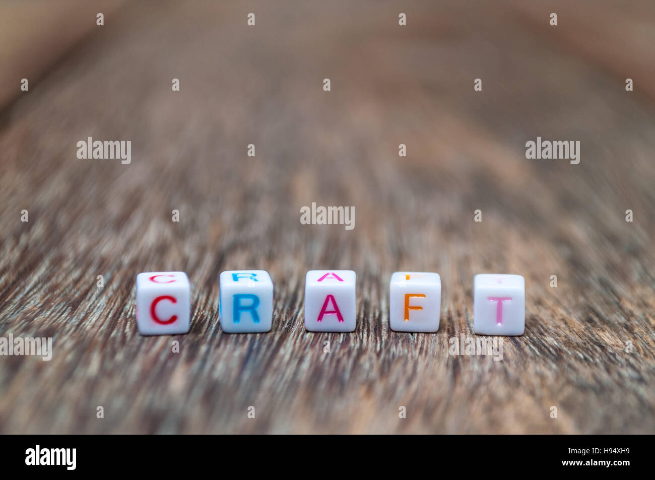 craft word arranged from character cubes on wood table top. closeup ...