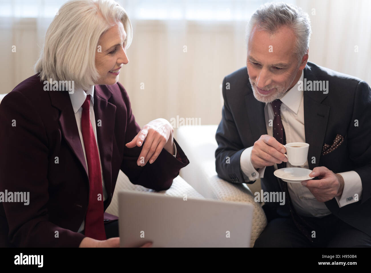 Delighted businesswoman and her colleague working with the laptop Stock ...