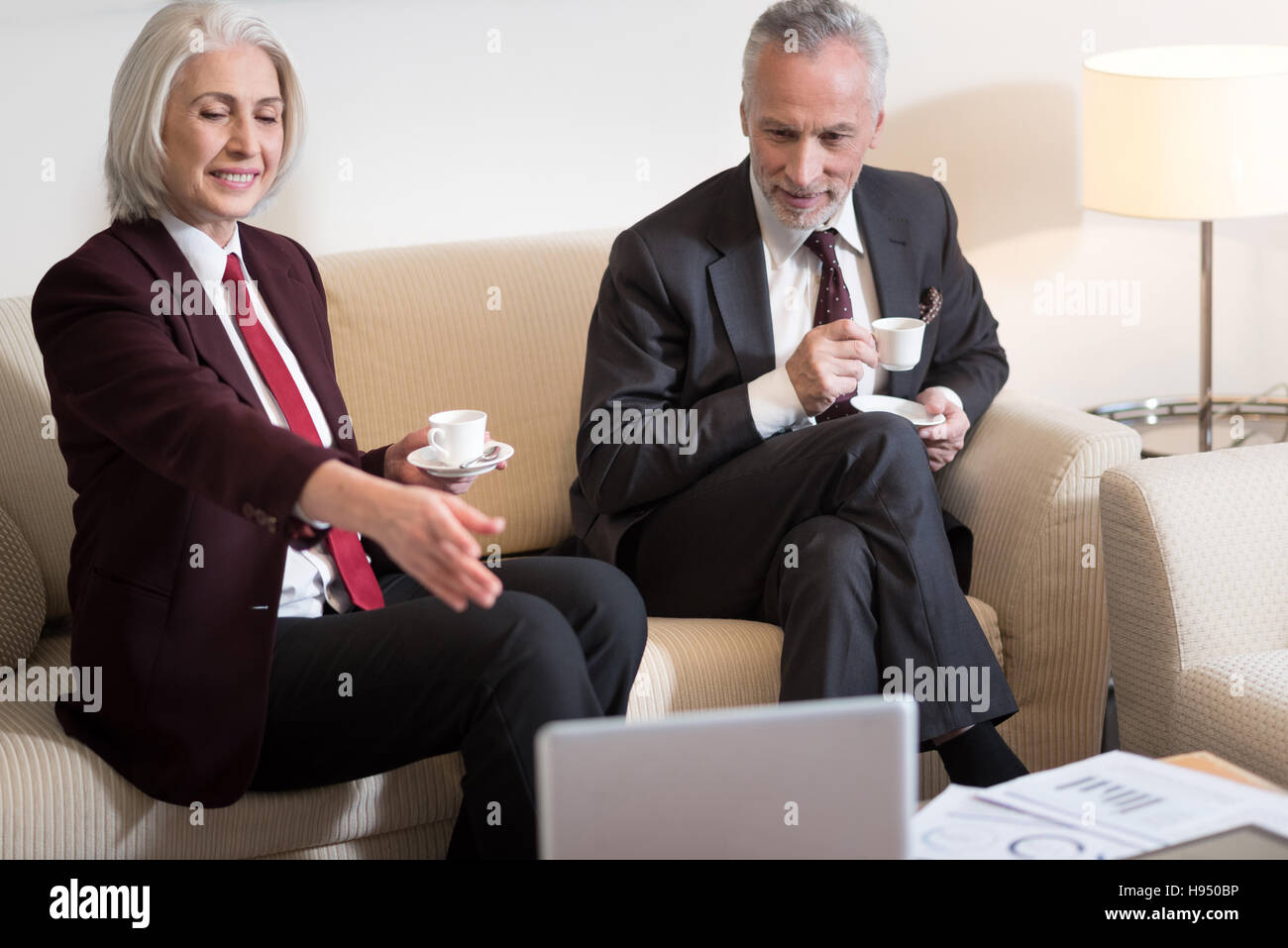 Happy businesswoman drinking coffee with her colleague Stock Photo - Alamy