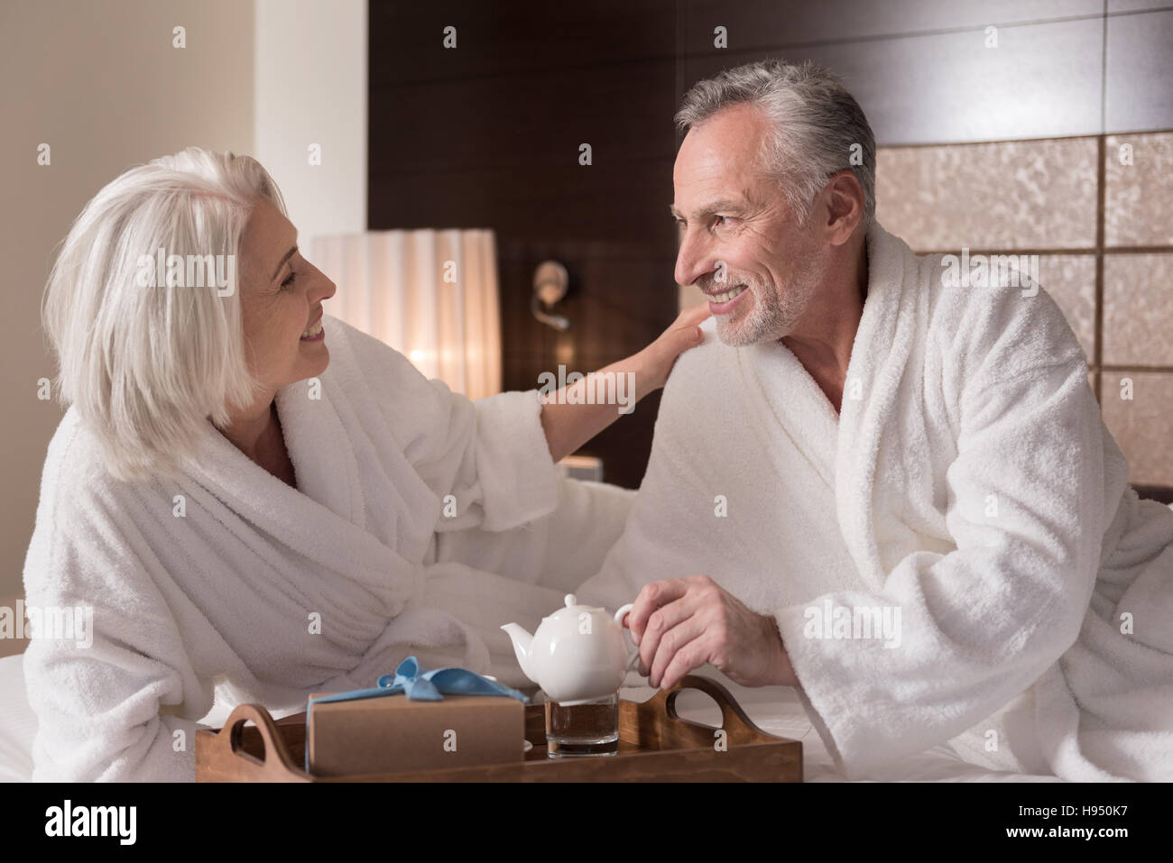 Delighted pleasant couple having drinking tea on the bed Stock Photo ...
