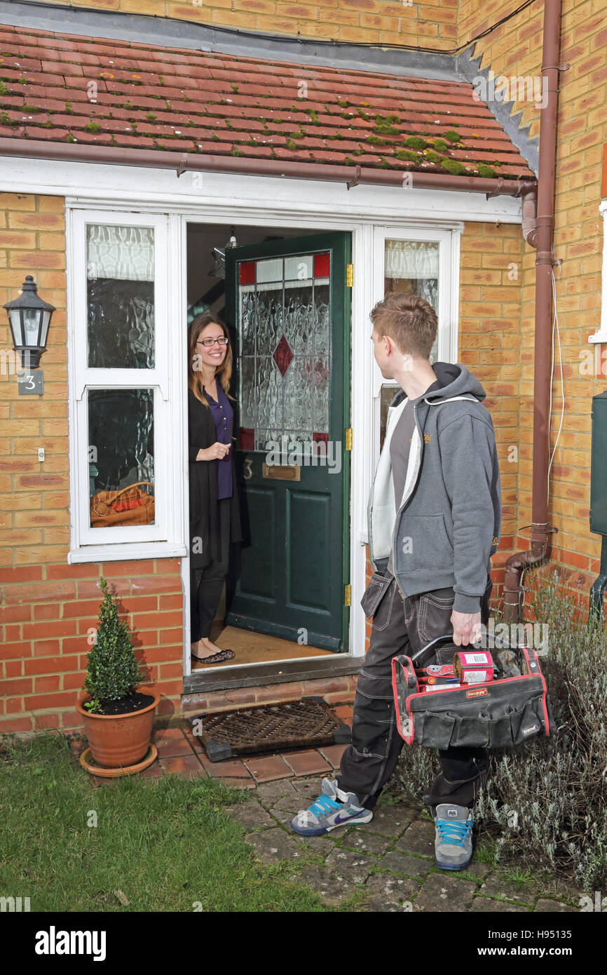 A young plumber/builder and a female householder talk as he leaves a ...