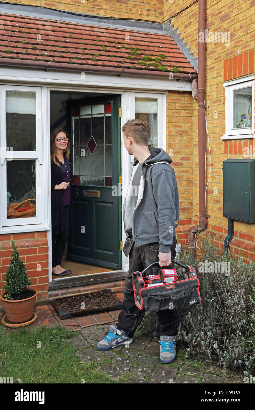 A young plumber/builder and a female householder talk as he leaves a ...