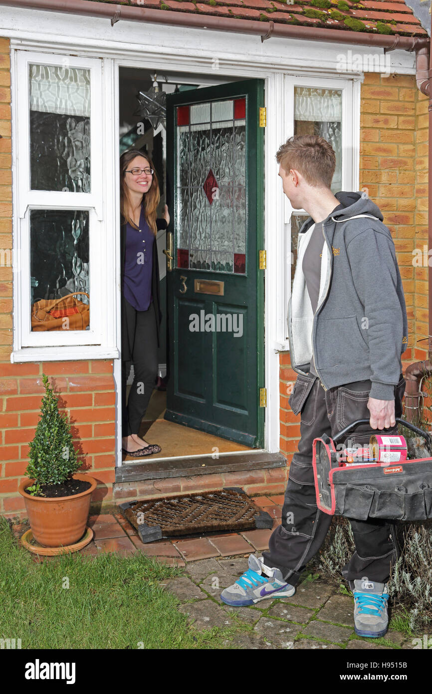 A young plumber/builder and a female householder talk as he leaves a ...
